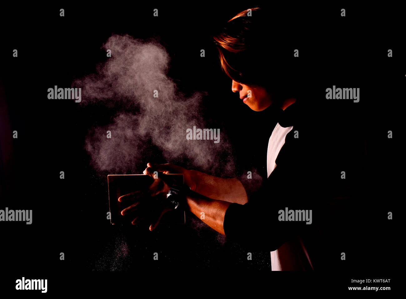 Young male model closes book. Powder in background, Pune, Maharashtra ...