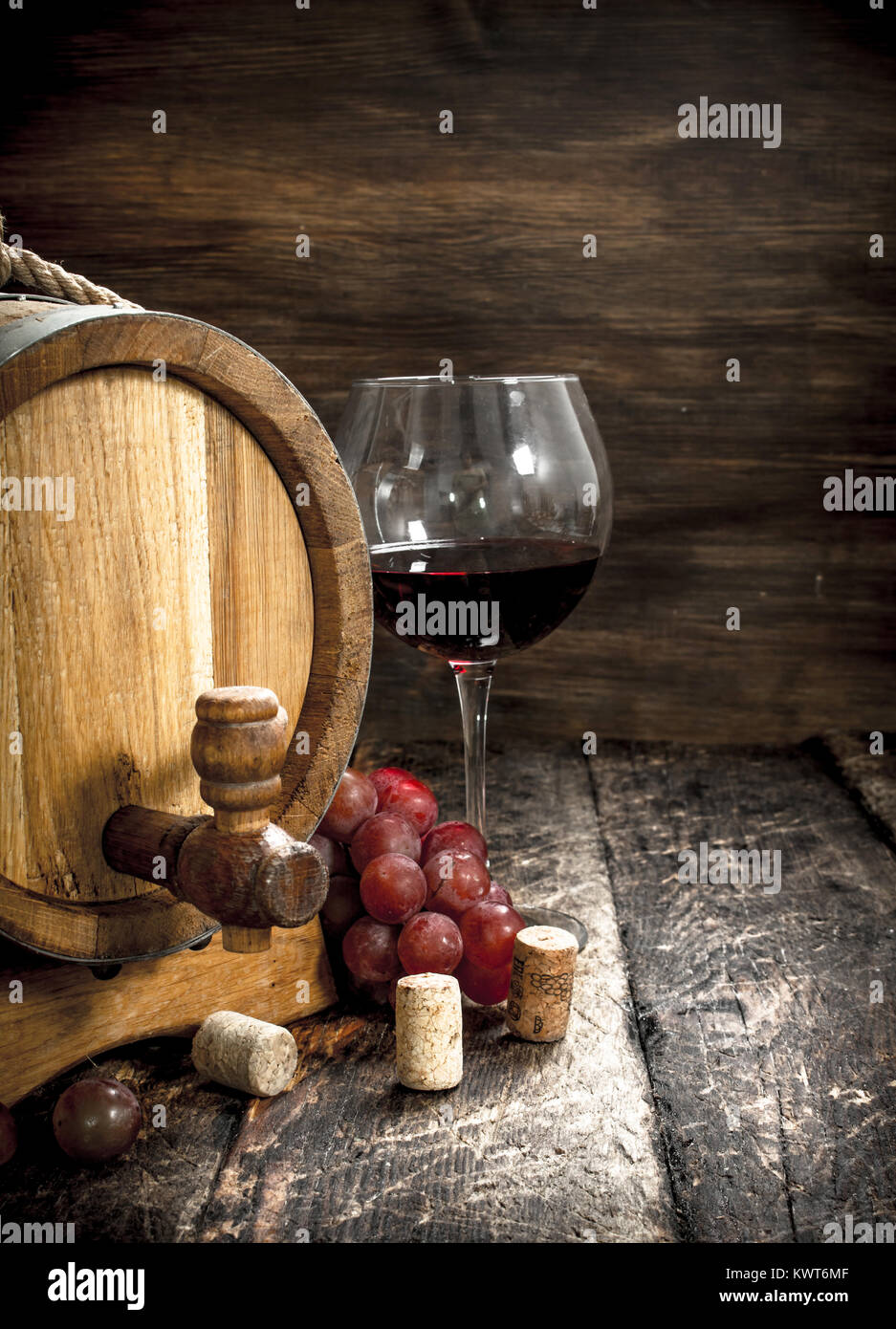 Wine background. A barrel with red wine and freshly grapes. On a wooden ...