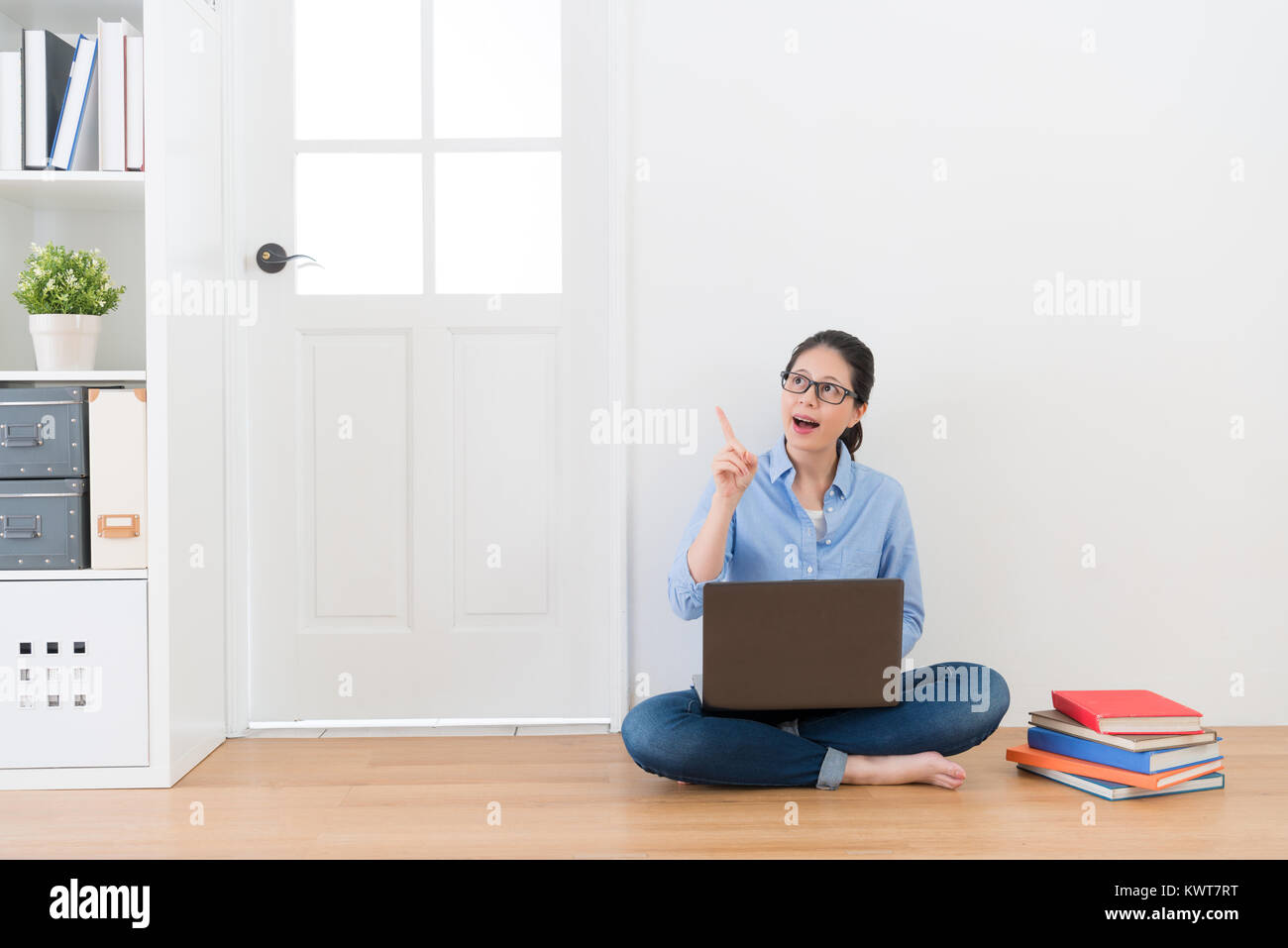 attractive woman sitting on wood floor at home using computer doing ...