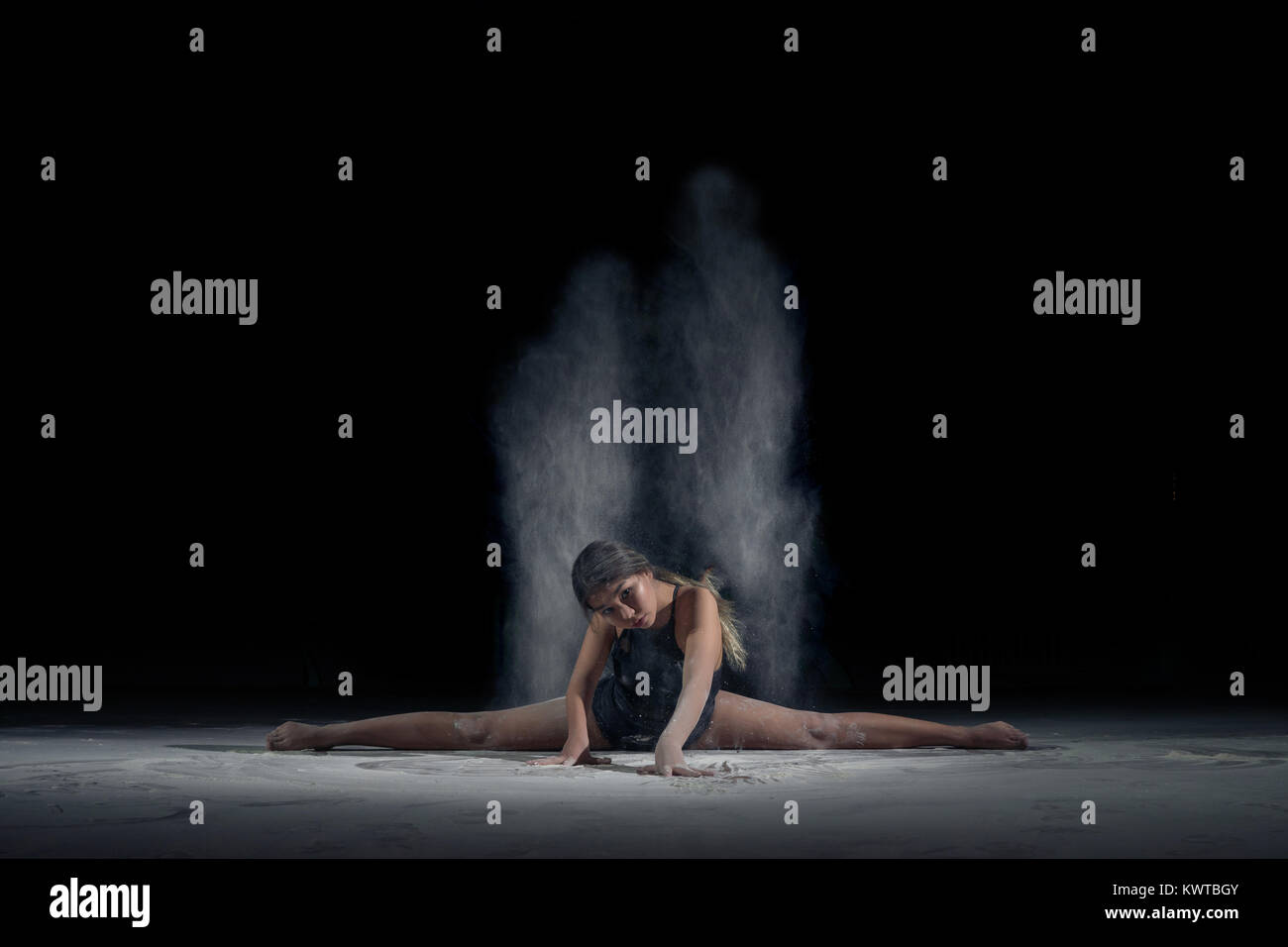 Girl dancing in the flour on the black background Stock Photo - Alamy