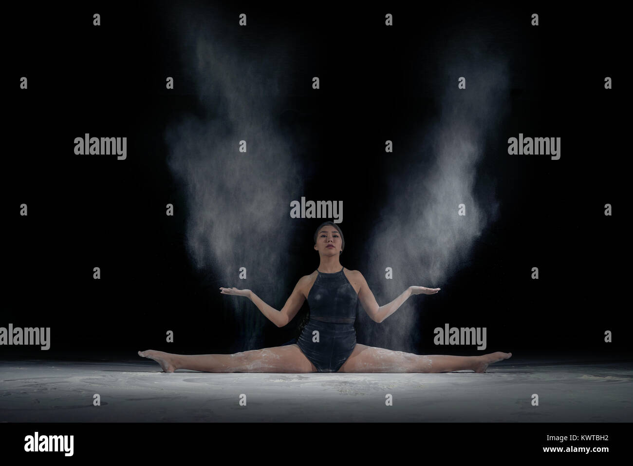 Girl dancing in the flour on the black background Stock Photo - Alamy