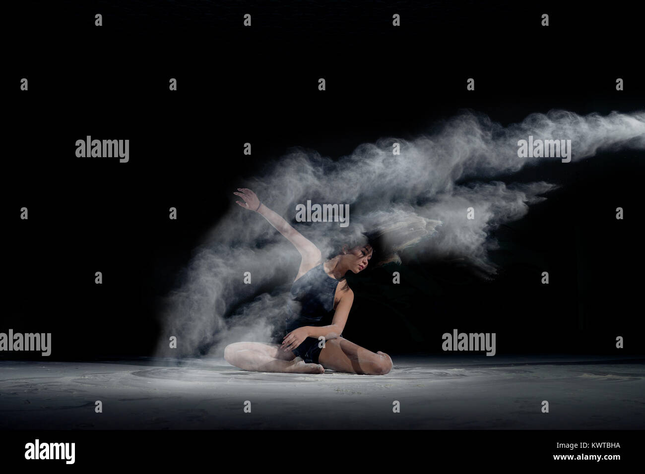 Girl dancing in the flour on the black background Stock Photo - Alamy