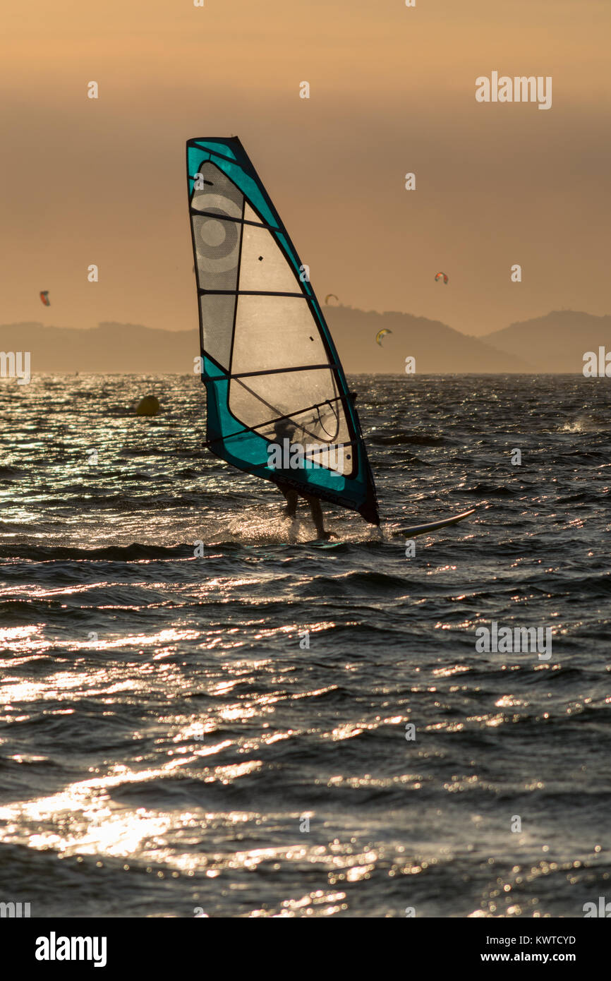 Sunset over the sea or ocean and extreme freestyle sport windsurfing ...