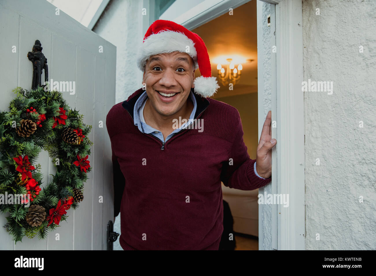 Point of view shot of a cheerful man in a santa hat welcoming you in to ...