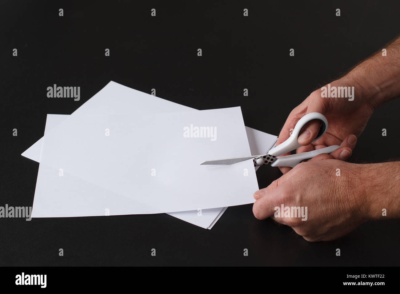 Male hands cutting paper with pair of scissors Stock Photo - Alamy