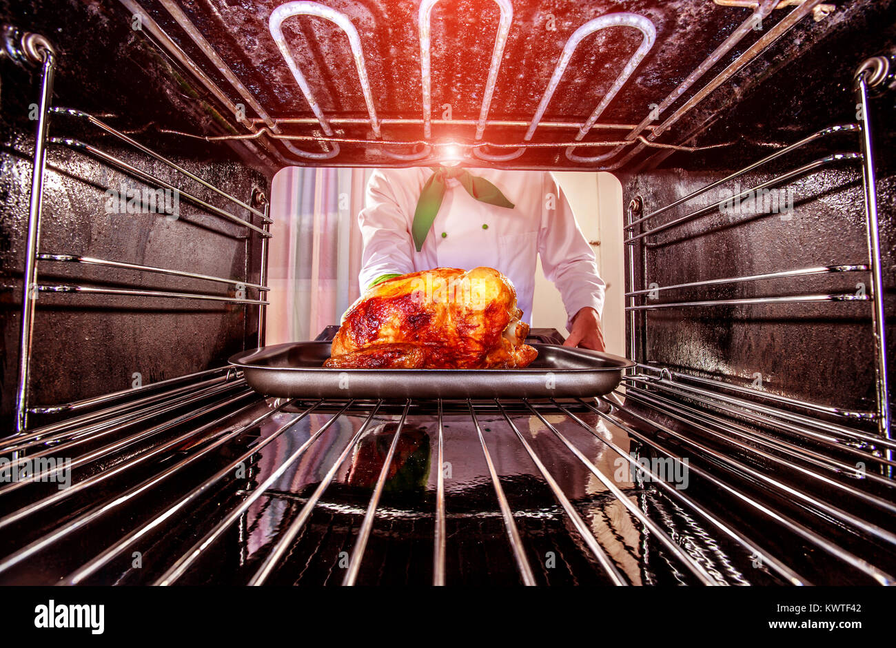 Chef prepares roast chicken in the oven, view from the inside of the ...