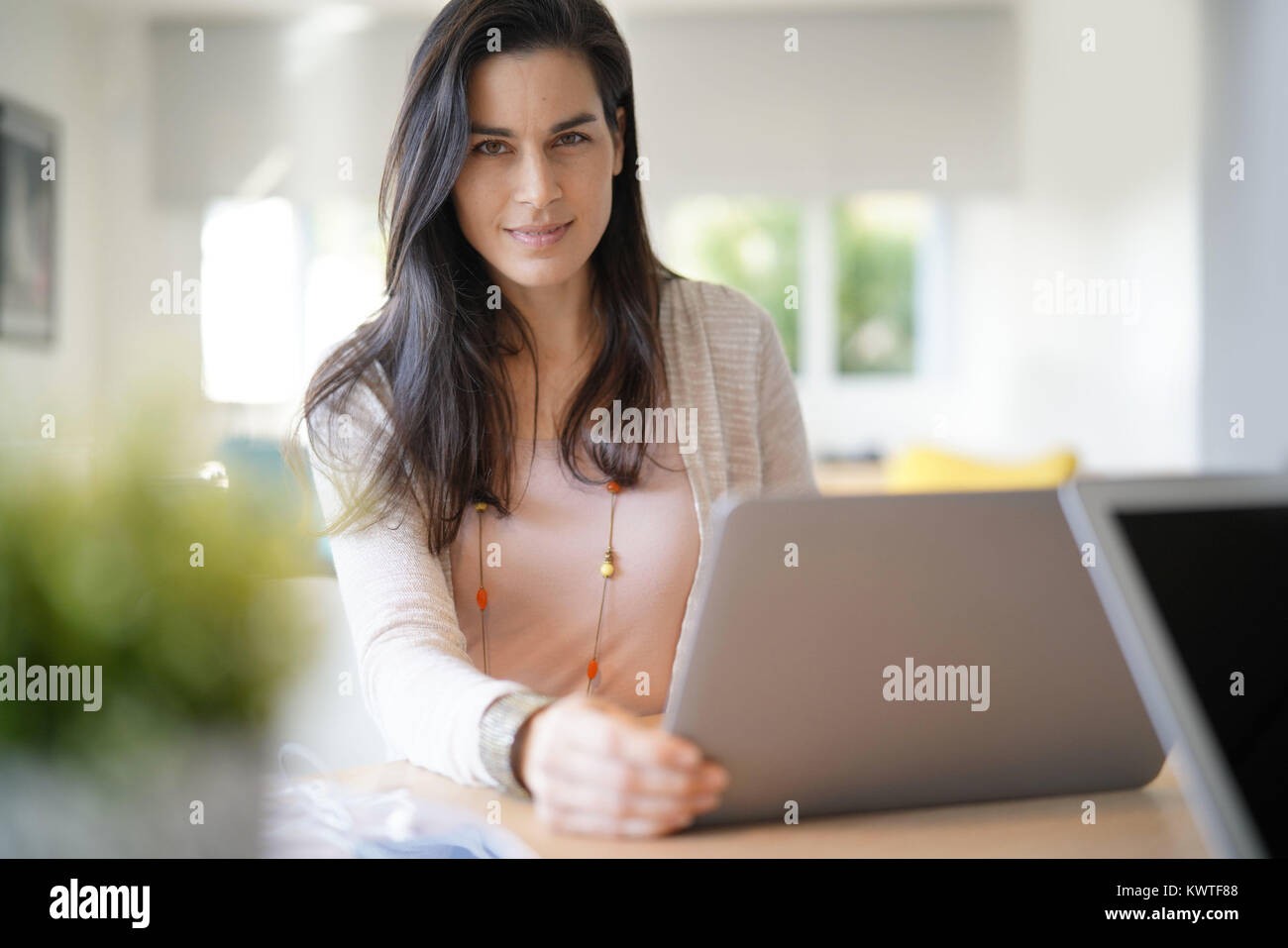Portrait of brunette girl working on laptop computer Stock Photo - Alamy