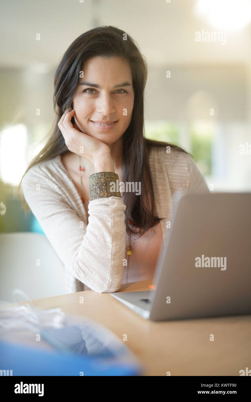 Portrait of brunette girl working on laptop computer Stock Photo - Alamy