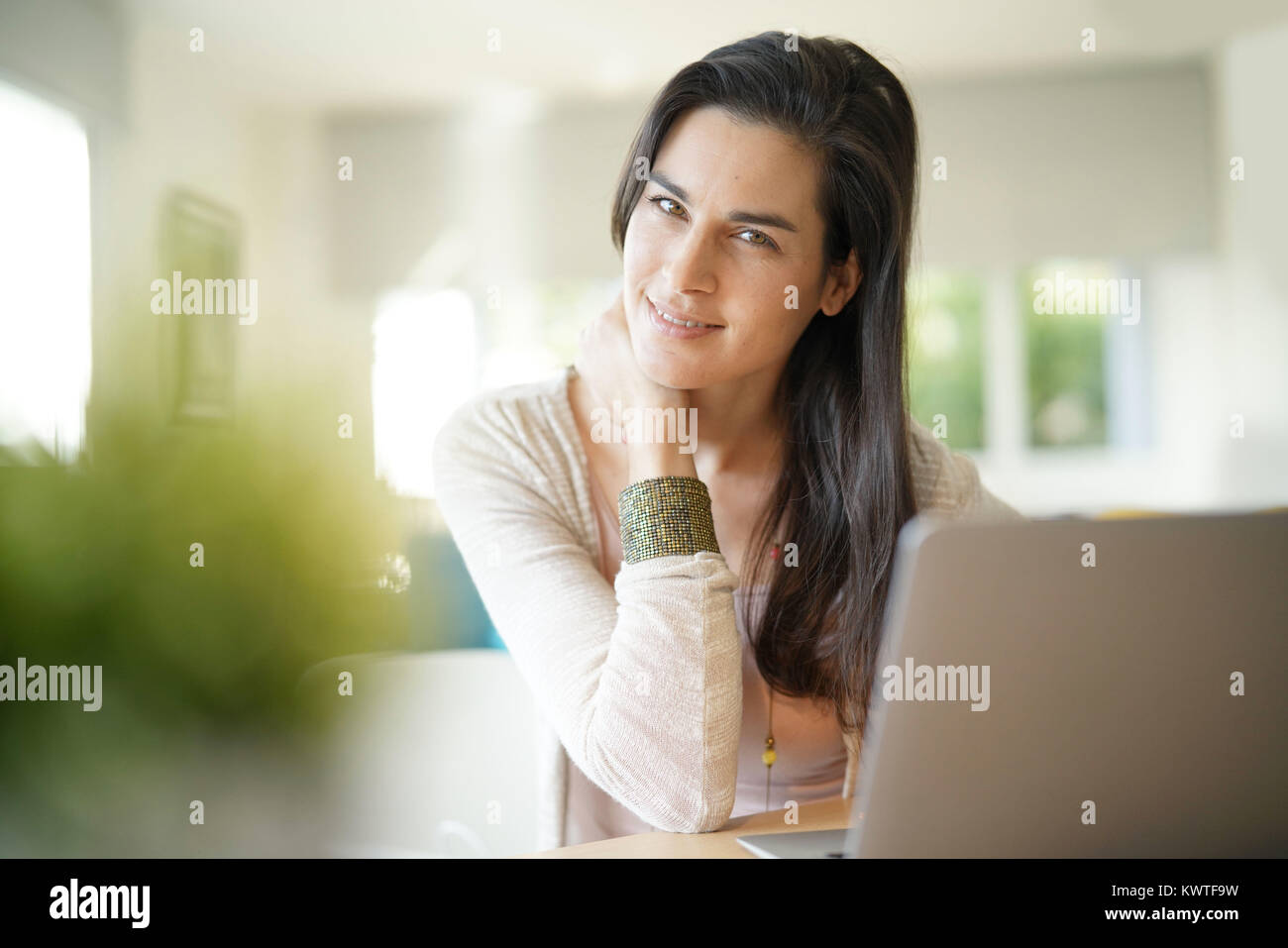 Portrait of brunette girl working on laptop computer Stock Photo - Alamy