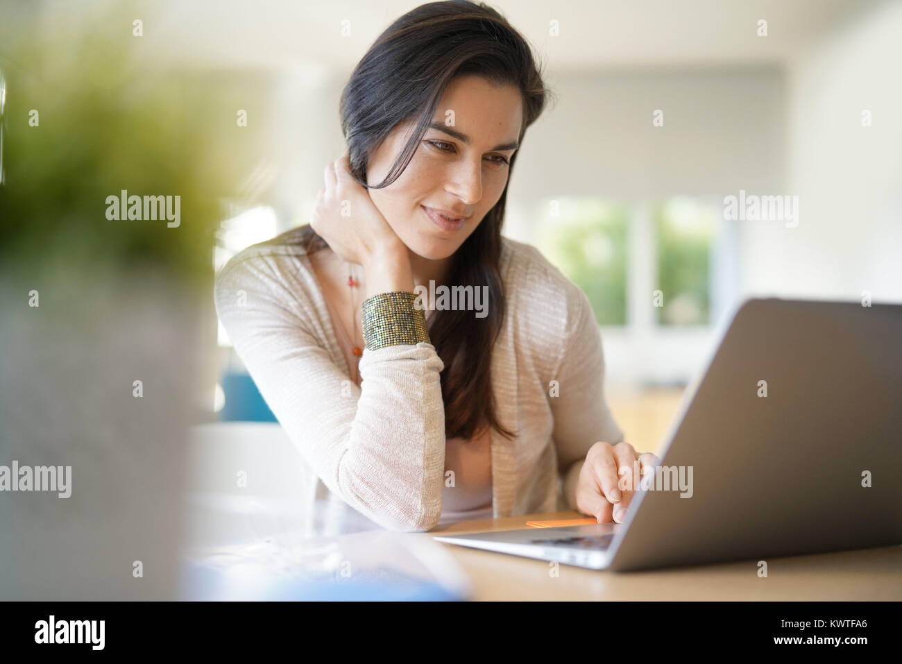 Portrait of brunette girl working on laptop computer Stock Photo - Alamy