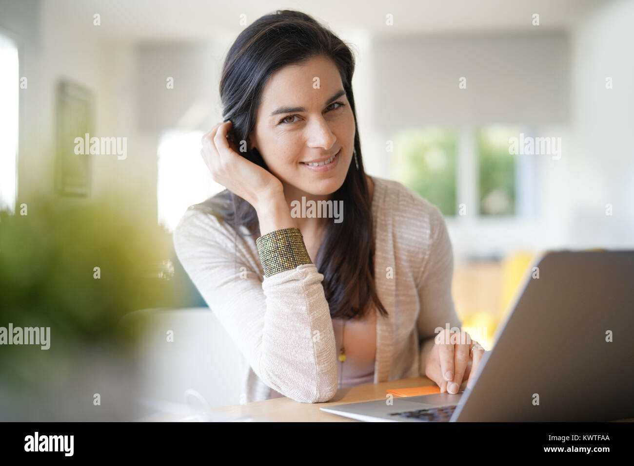 Portrait of brunette girl working on laptop computer Stock Photo - Alamy