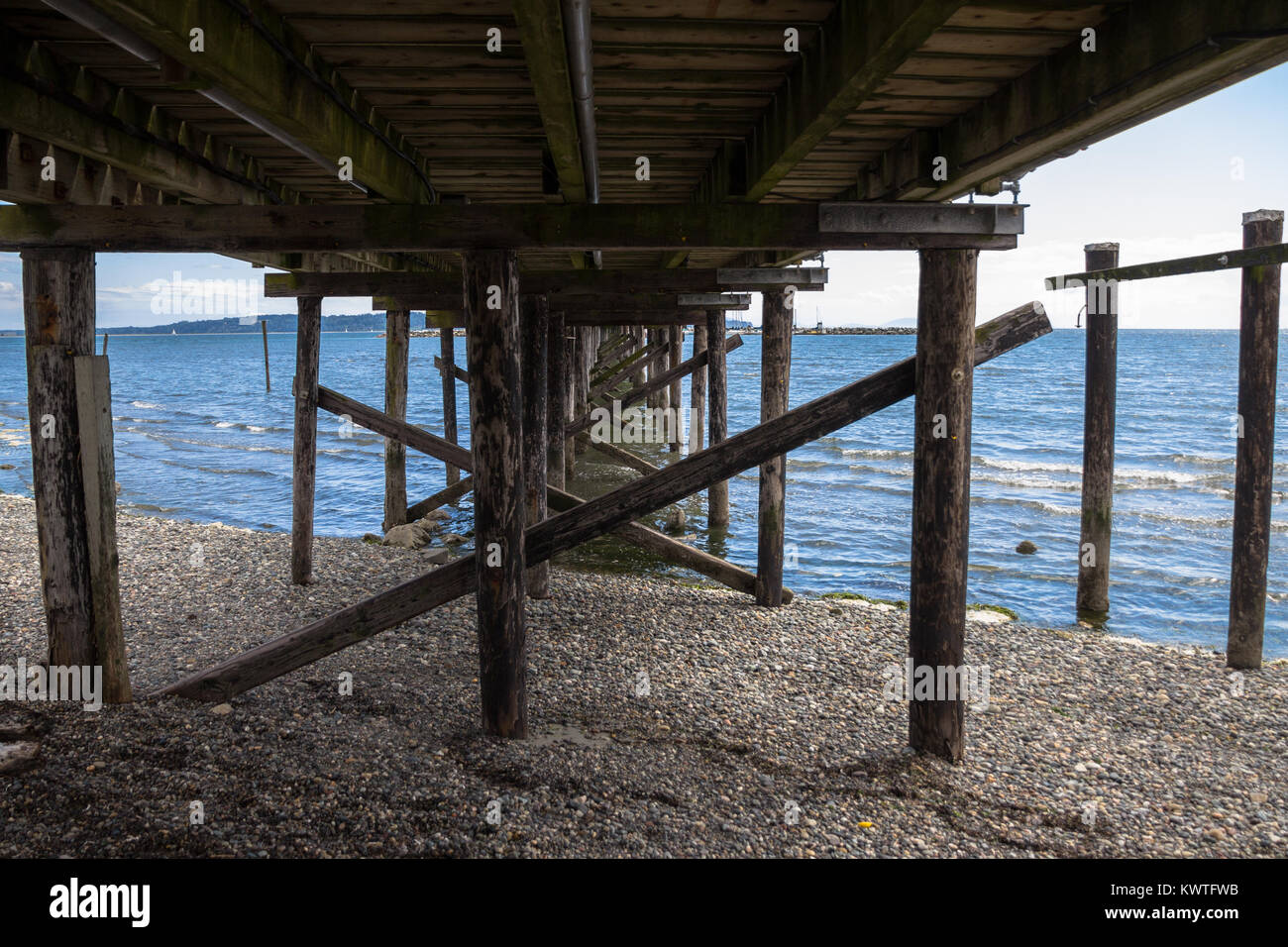 Under White Rock's pier looking out to sail boats moored at jetty ...