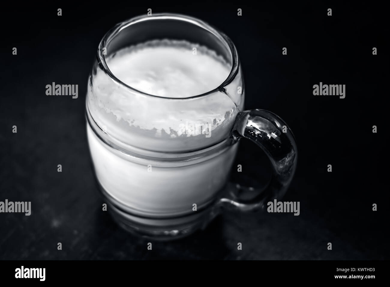 Unsweetened milk in a transparent glass on wooden surface Stock Photo ...