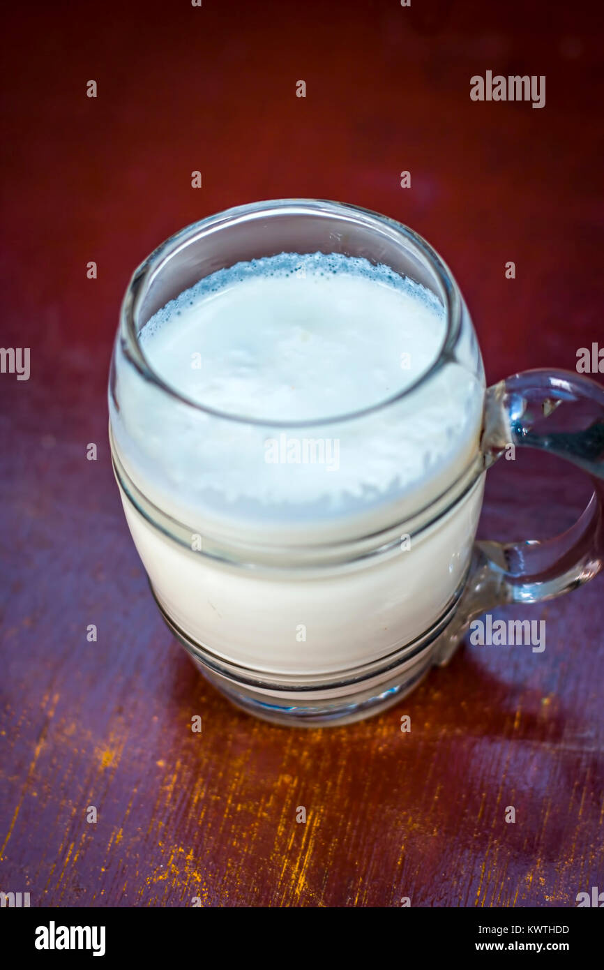 Unsweetened milk in a transparent glass on wooden surface Stock Photo ...
