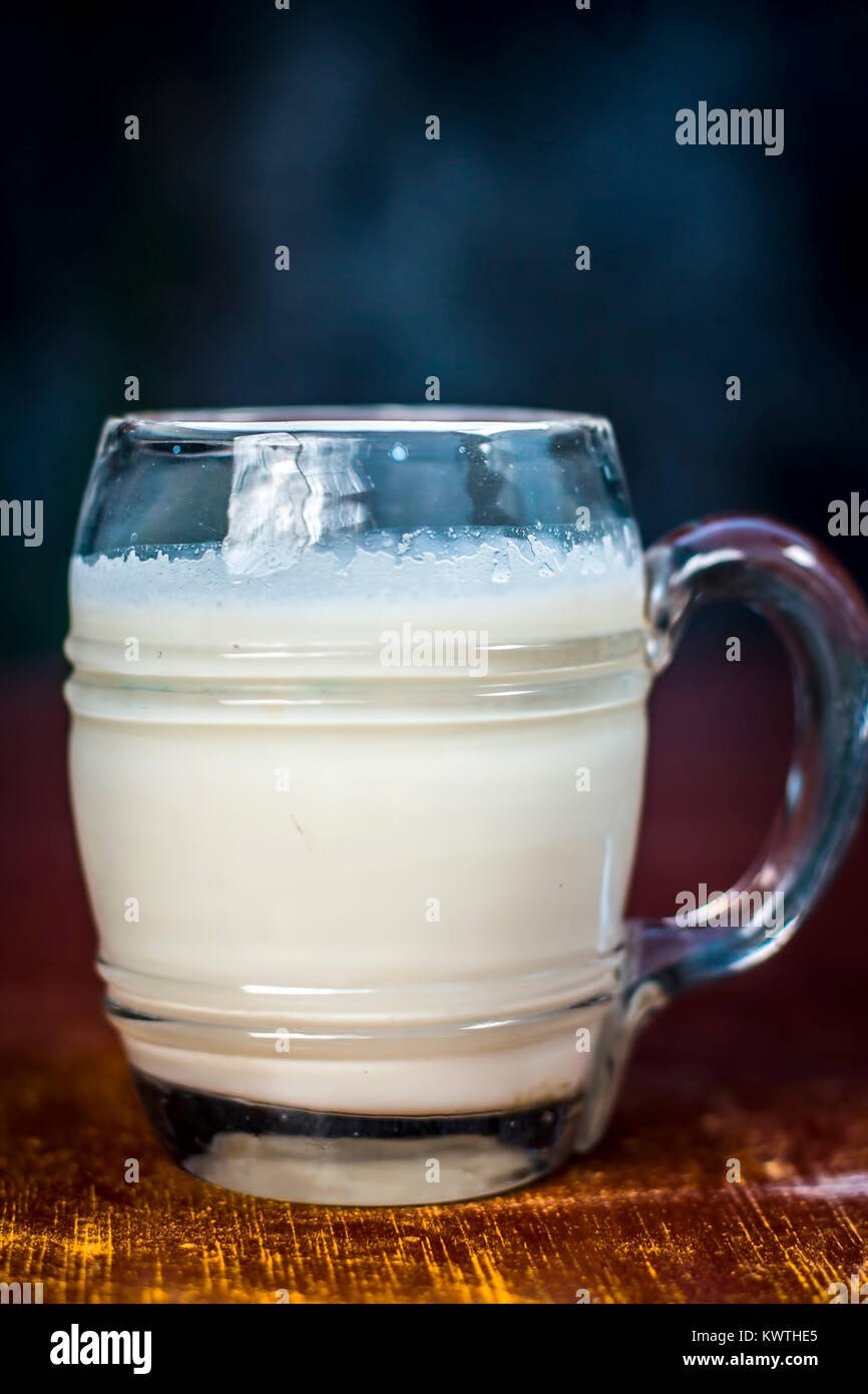 Unsweetened milk in a transparent glass on wooden surface Stock Photo ...