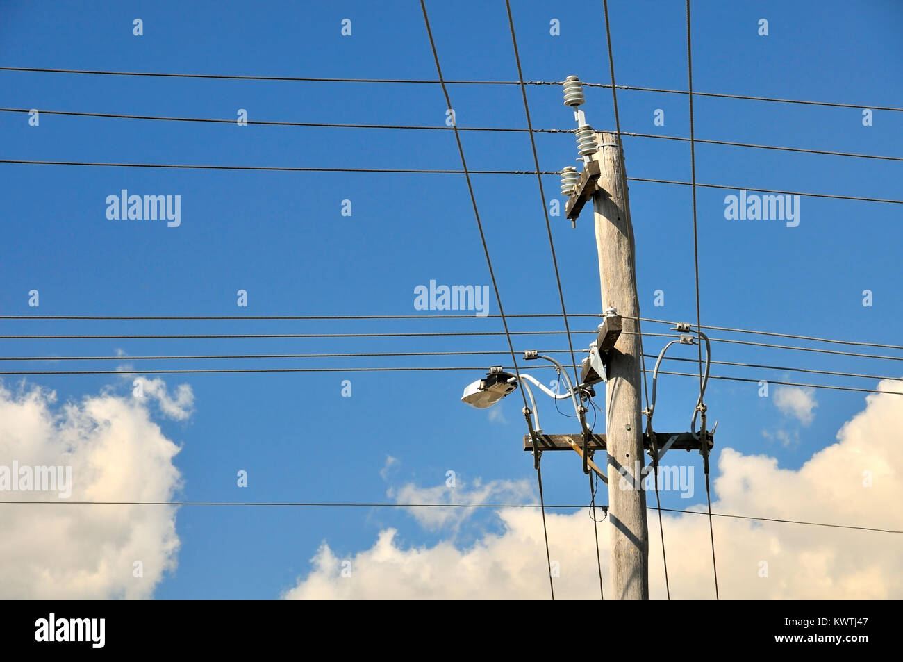 Metallic electric pole with a complex network of power cables running ...