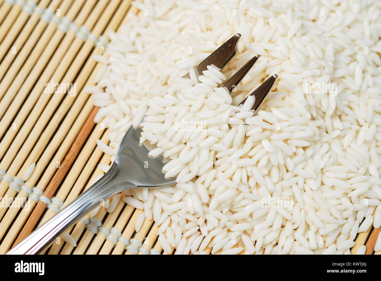 Fork in pile of freshly harvested white rice, staple diet in Asia Stock ...