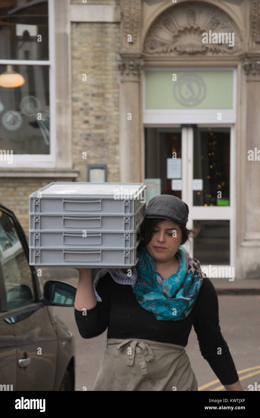 Cambridge Uk Baker assistant carrying trays Stock Photo - Alamy