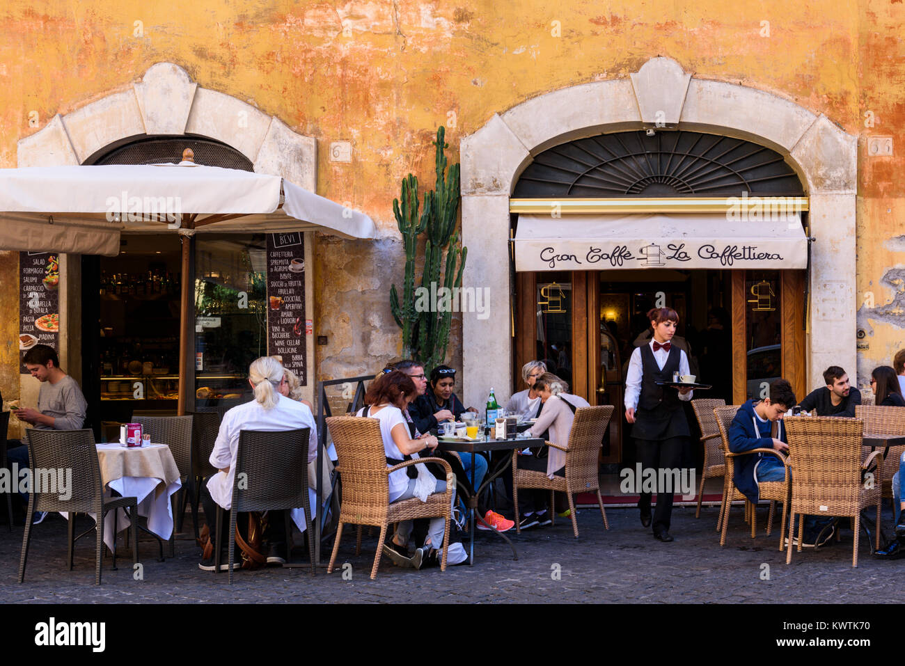 Tourists drink coffee al fresco in a cafeteria in the Center of Rome ...