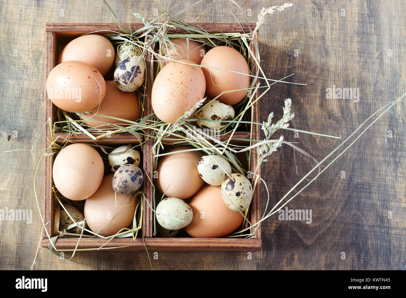 Chicken and quail eggs in a wooden box. Rustic style, selective focus ...