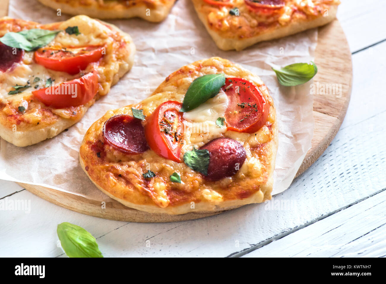 Heart shaped mini pizzas over wooden background with copy space. Mini ...