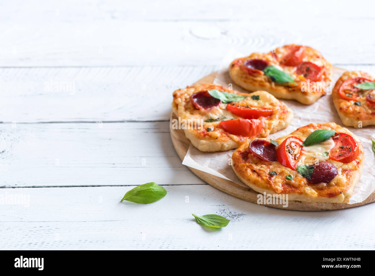 Heart shaped mini pizzas over wooden background with copy space. Mini ...