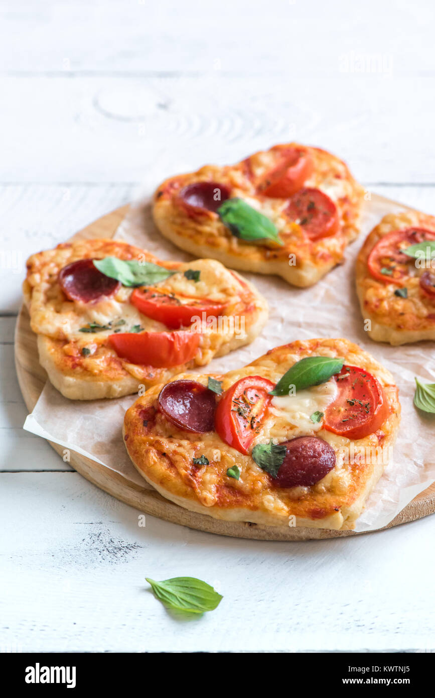 Heart shaped mini pizzas over wooden background with copy space. Mini ...