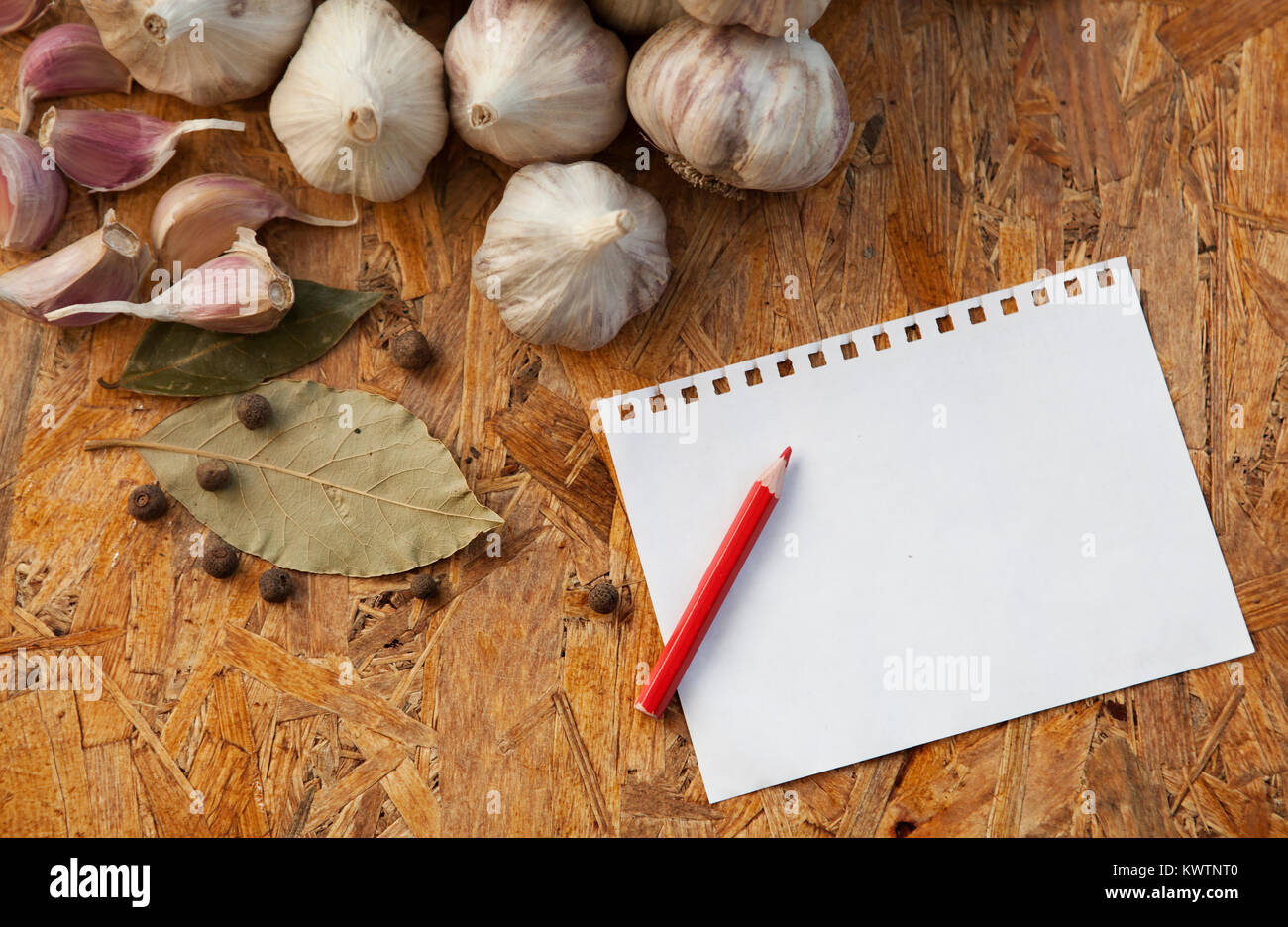 blank for recipe or note with pensil on wooden surface with garlic and ...