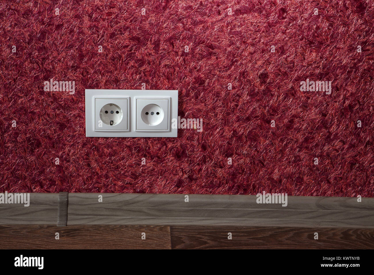 white european electric point in the wall with red wallpaper Stock ...