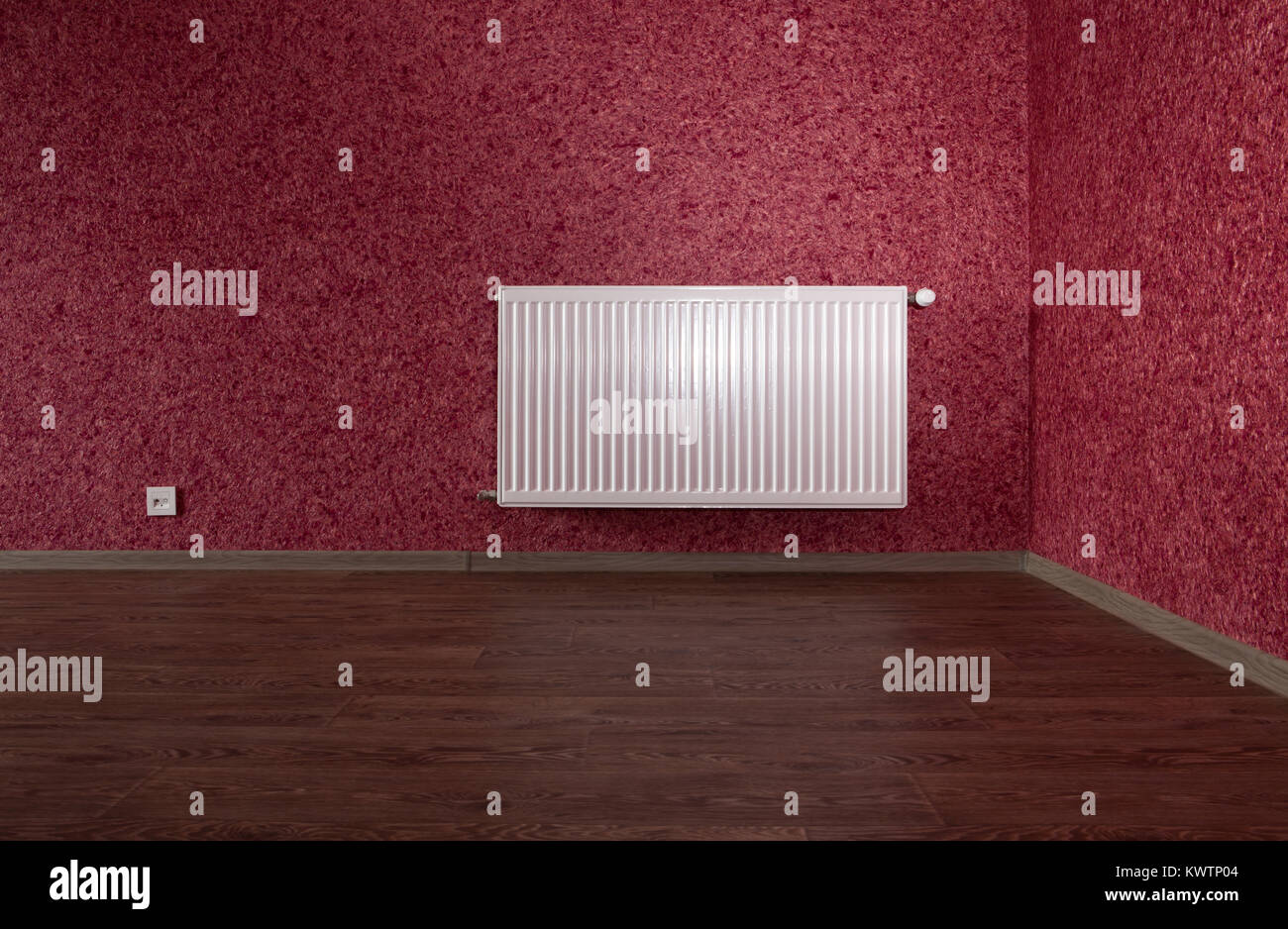 white heating radiator under in red room Stock Photo - Alamy