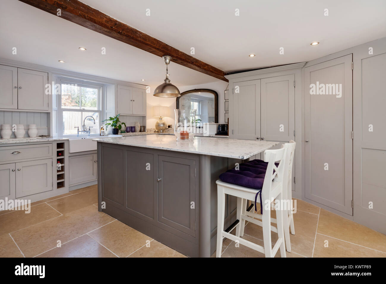 Modern looking kitchen with marble top island breakfast bar decorated ...