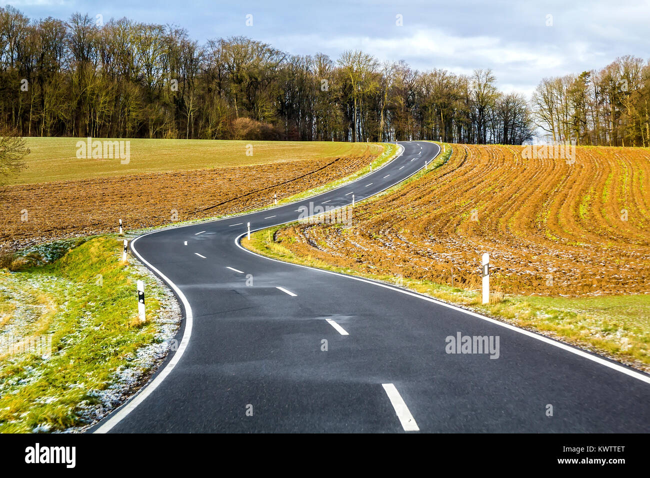 Empty black asphalt road between green fields Stock Photo - Alamy