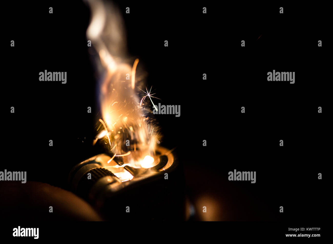 Igniting a lighter on a black background Stock Photo - Alamy