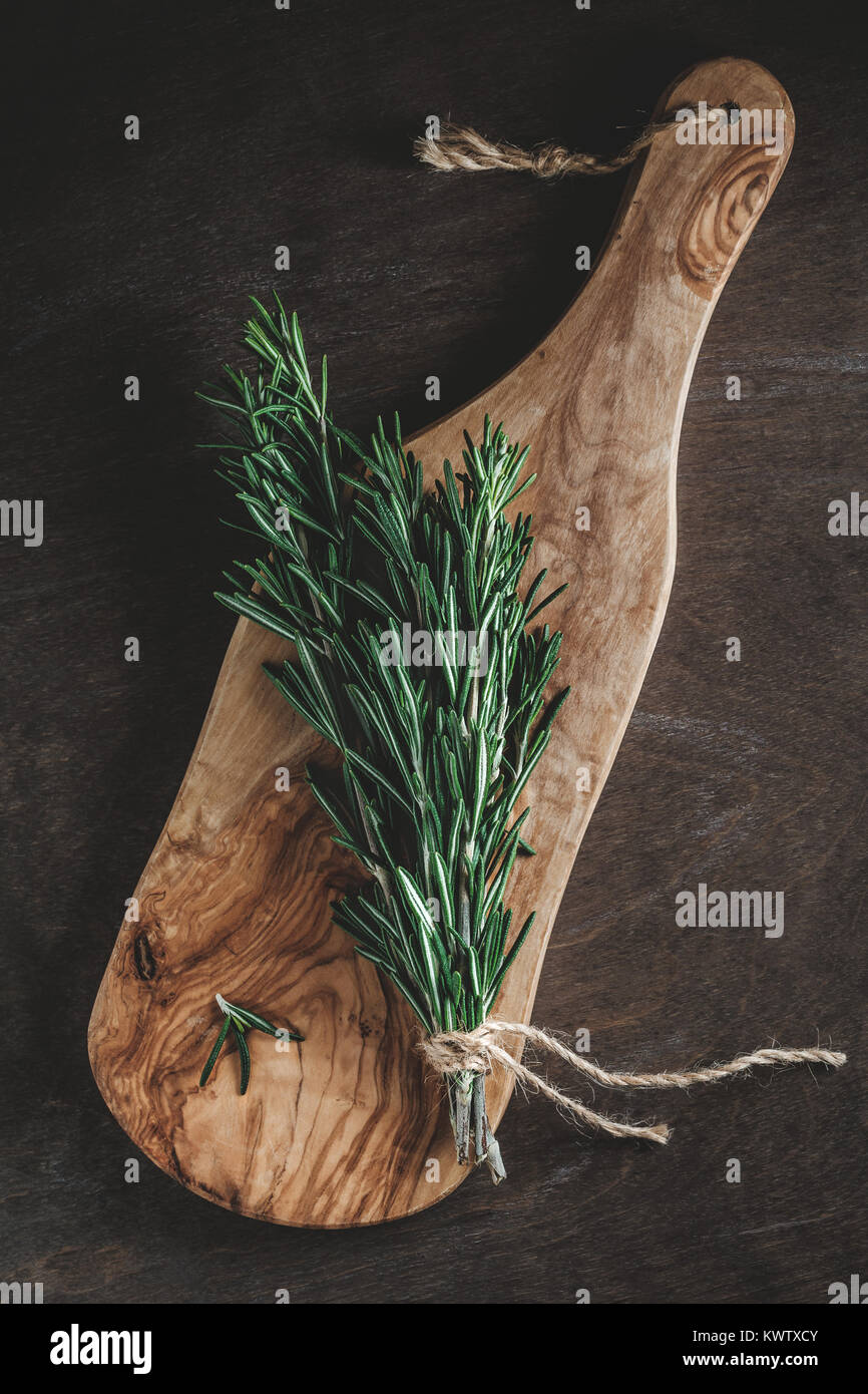 The branch of fresh rosemary on the rustic board. Top view Stock Photo ...