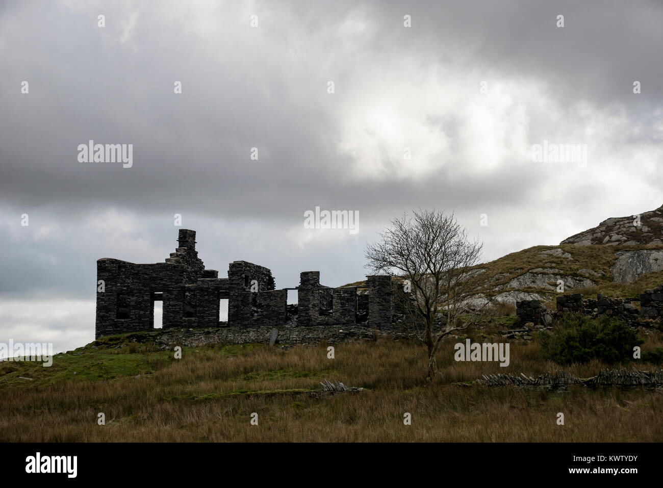 Dark outline of old quarry buildings against a grey sky at Cwmorthin ...