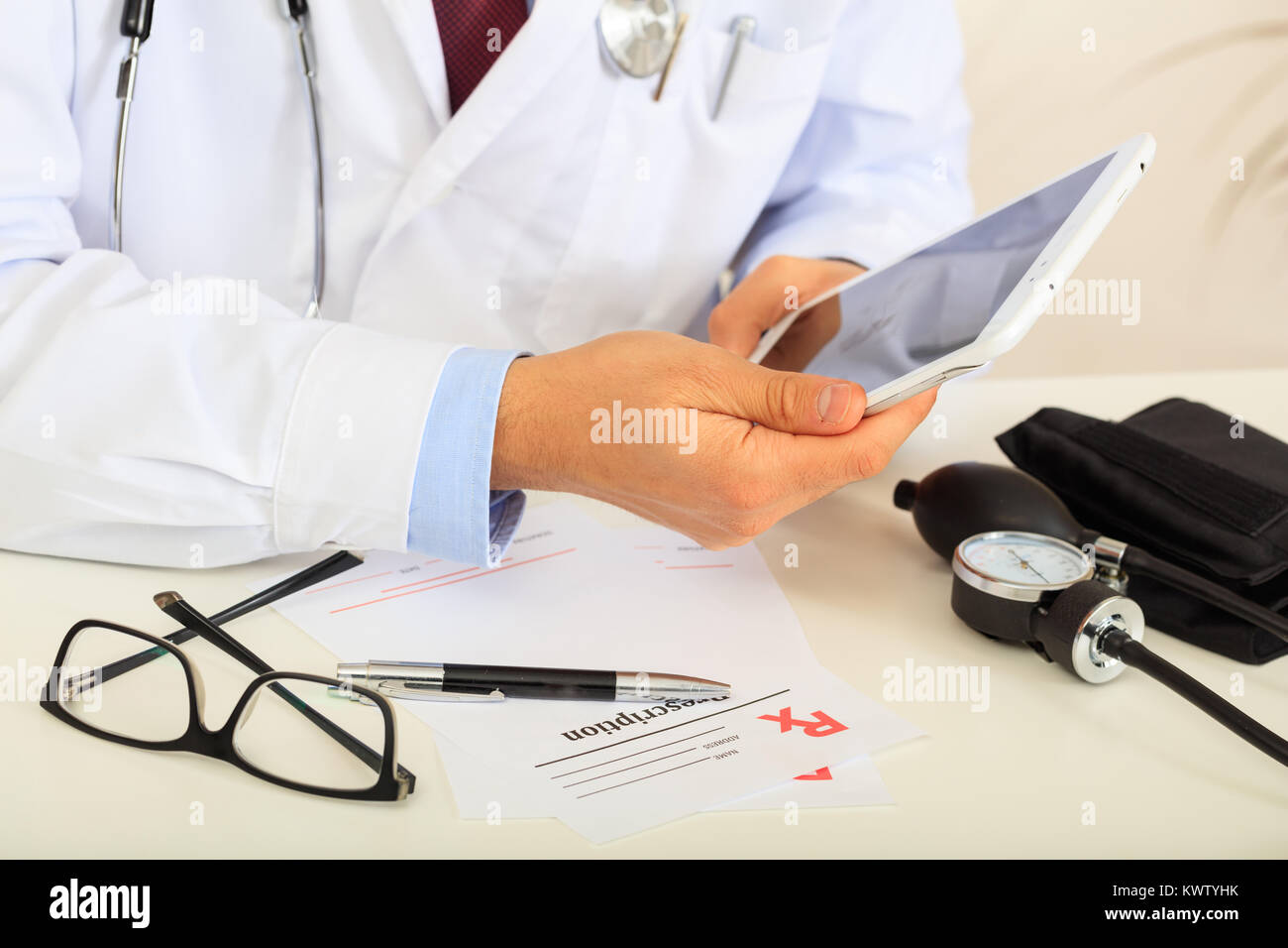 Doctor working with a tablet in his office Stock Photo - Alamy