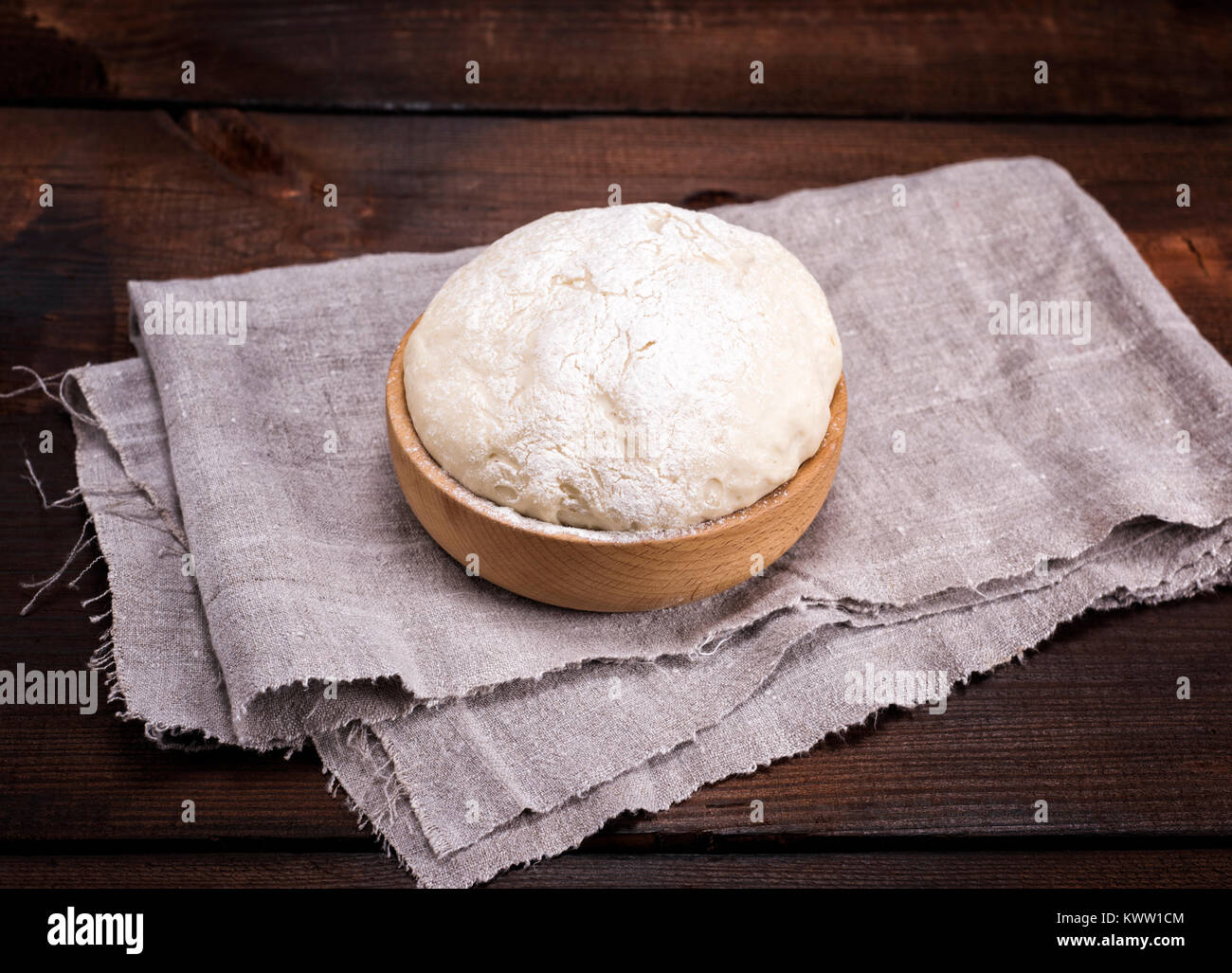 yeast dough in a wooden bowl on a gray napkin, top view Stock Photo - Alamy