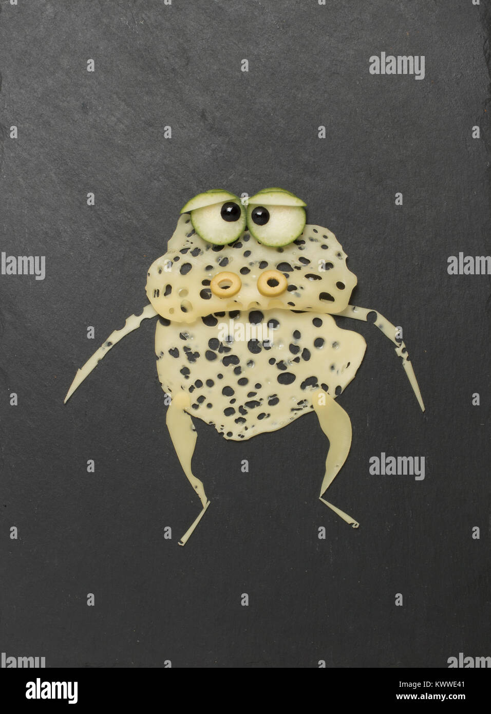 Frog made with cheese on black background Stock Photo - Alamy
