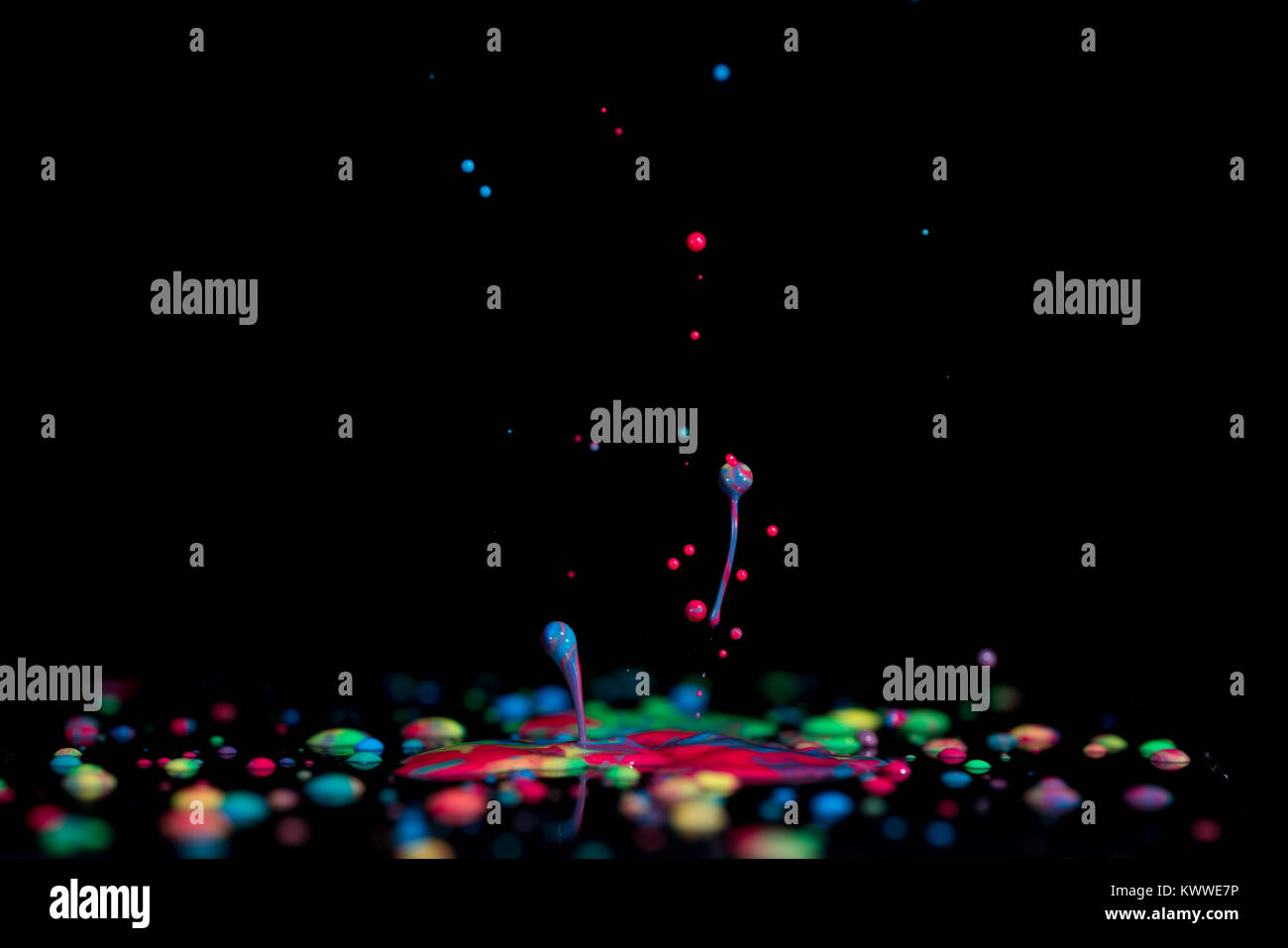 Splash of colorful liquid paint on a black background paint splash on ...
