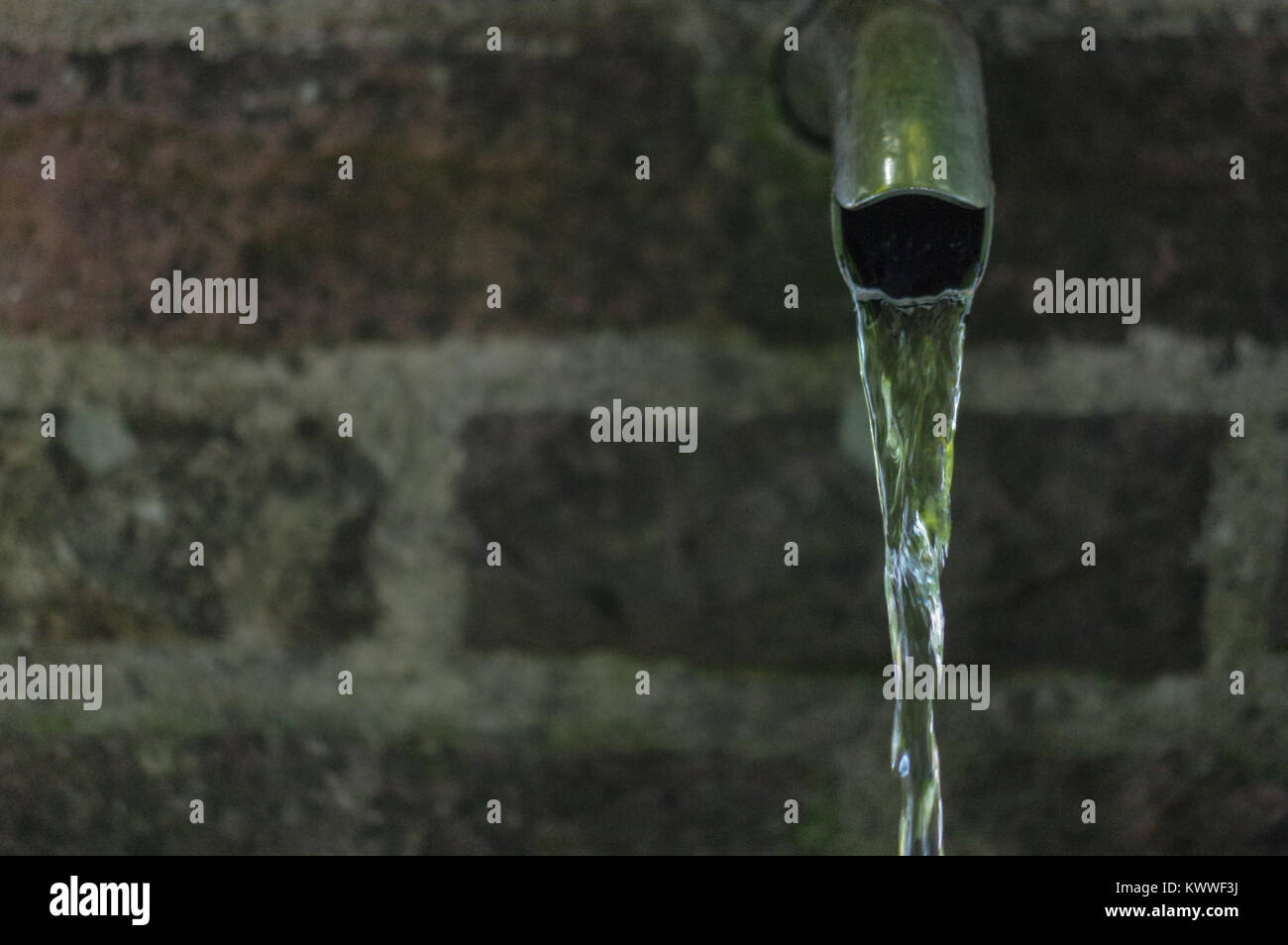 Close up of running water from a tap with a stone background Stock ...