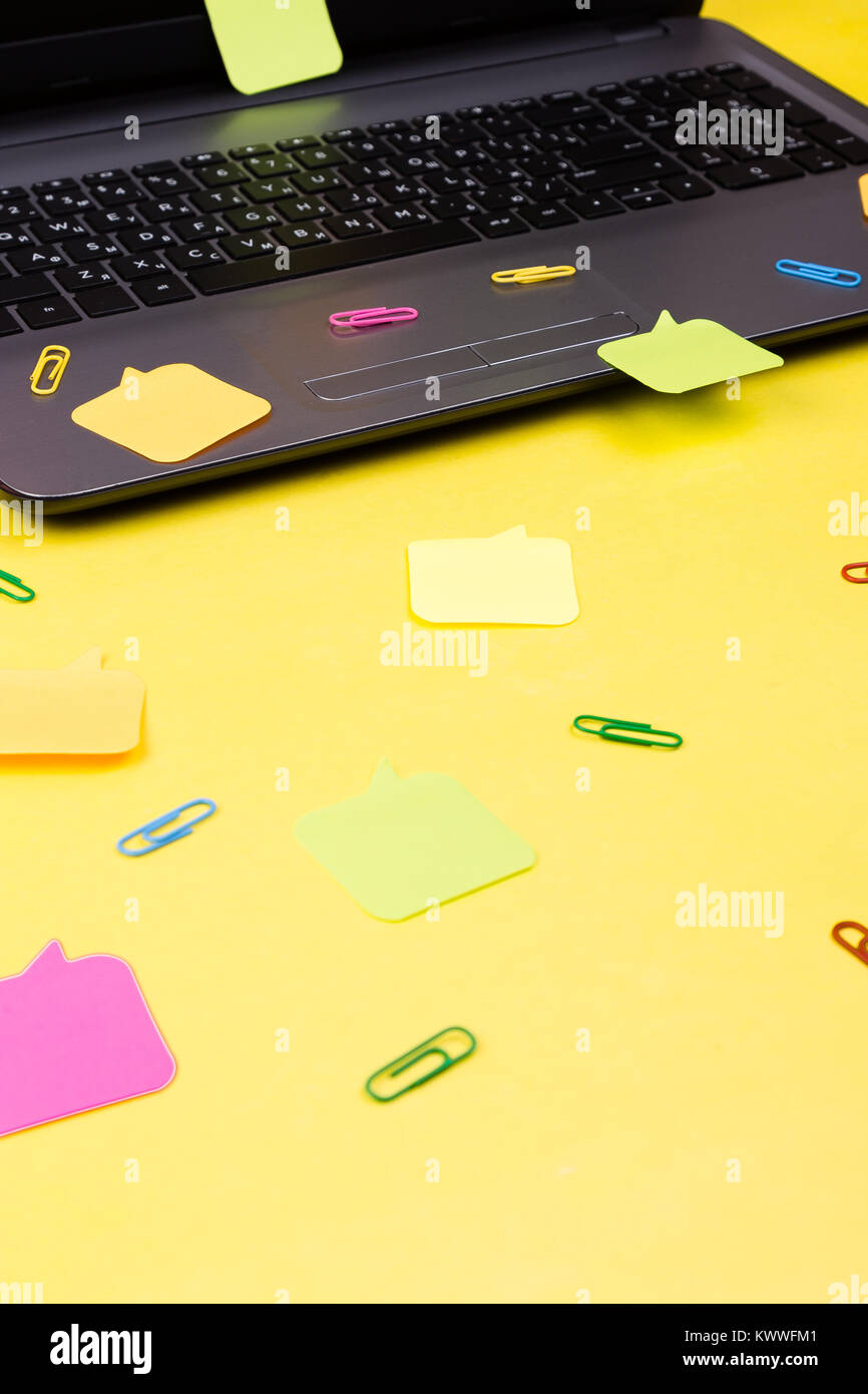 Notebook with colorful stickers on yellow paper background. Workplace ...