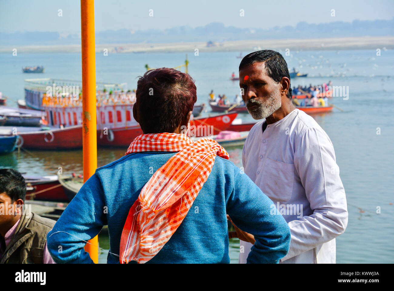 Varanasi, Uttar Pradesh, India, two indian men chatting by the ganges ...