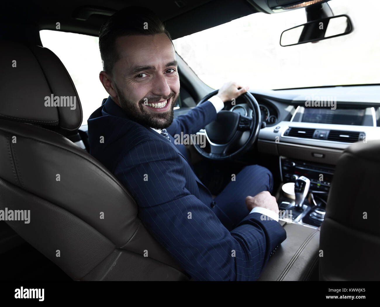 Successful man sitting behind the wheel of a car Stock Photo - Alamy