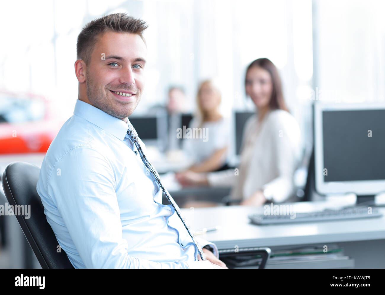 employee sitting behind a Desk and looking at the camera. photo with ...