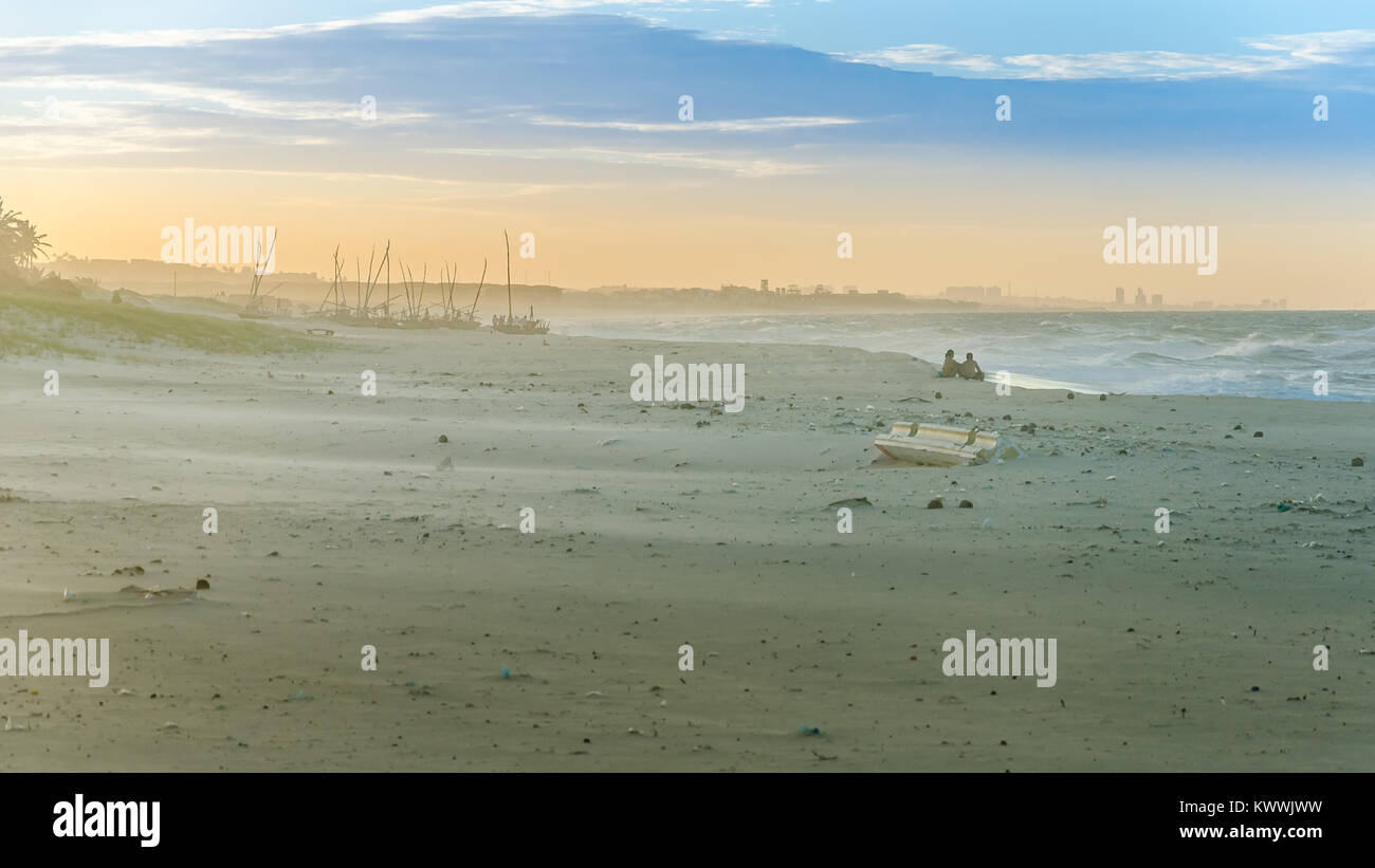 Couple on the beach at the sunset looking around Stock Photo - Alamy