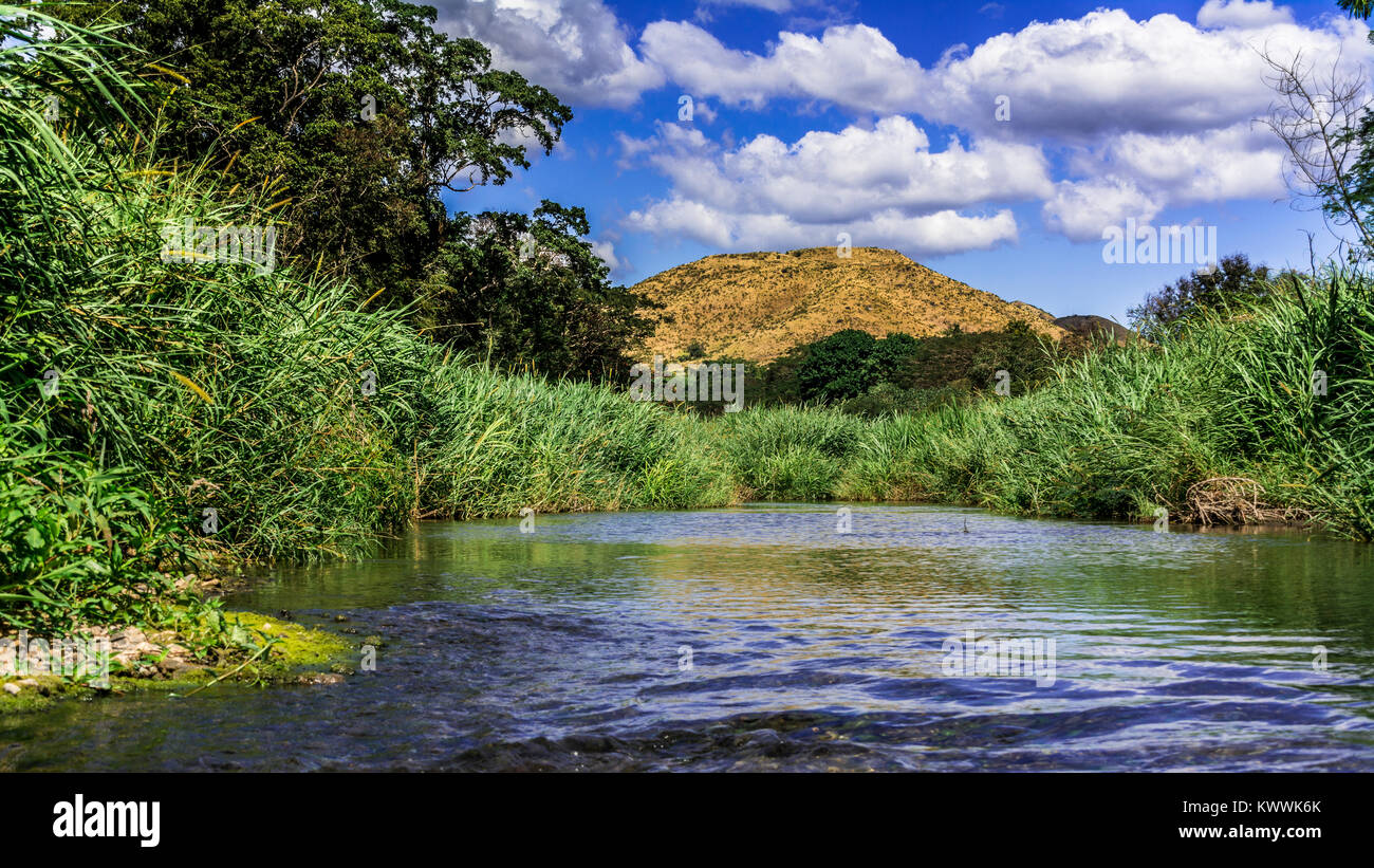 A beautiful river at the bottom of a mountain range in Coamo, Puerto ...