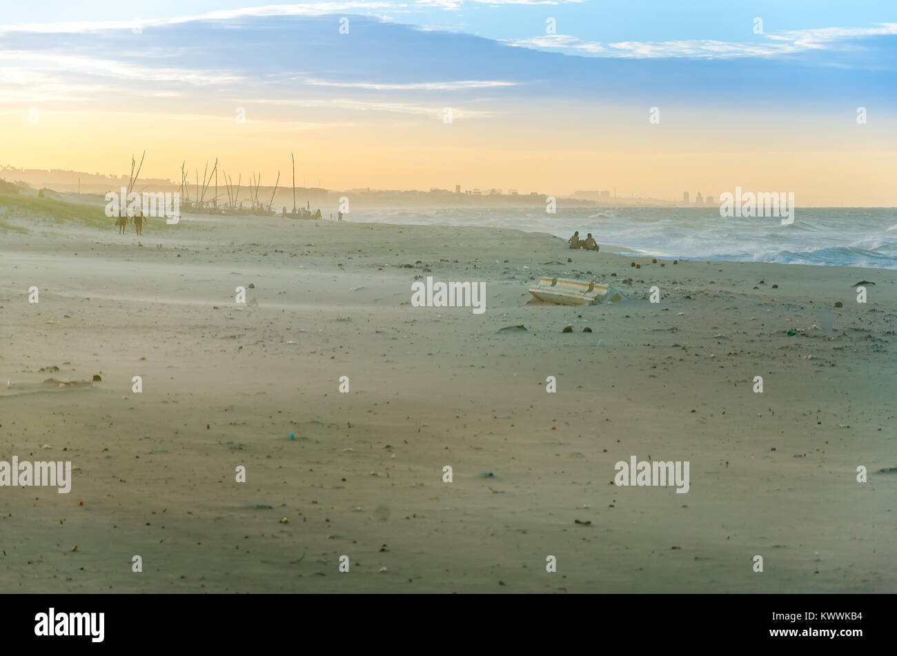 Couple on the beach at the sunset looking around Stock Photo - Alamy