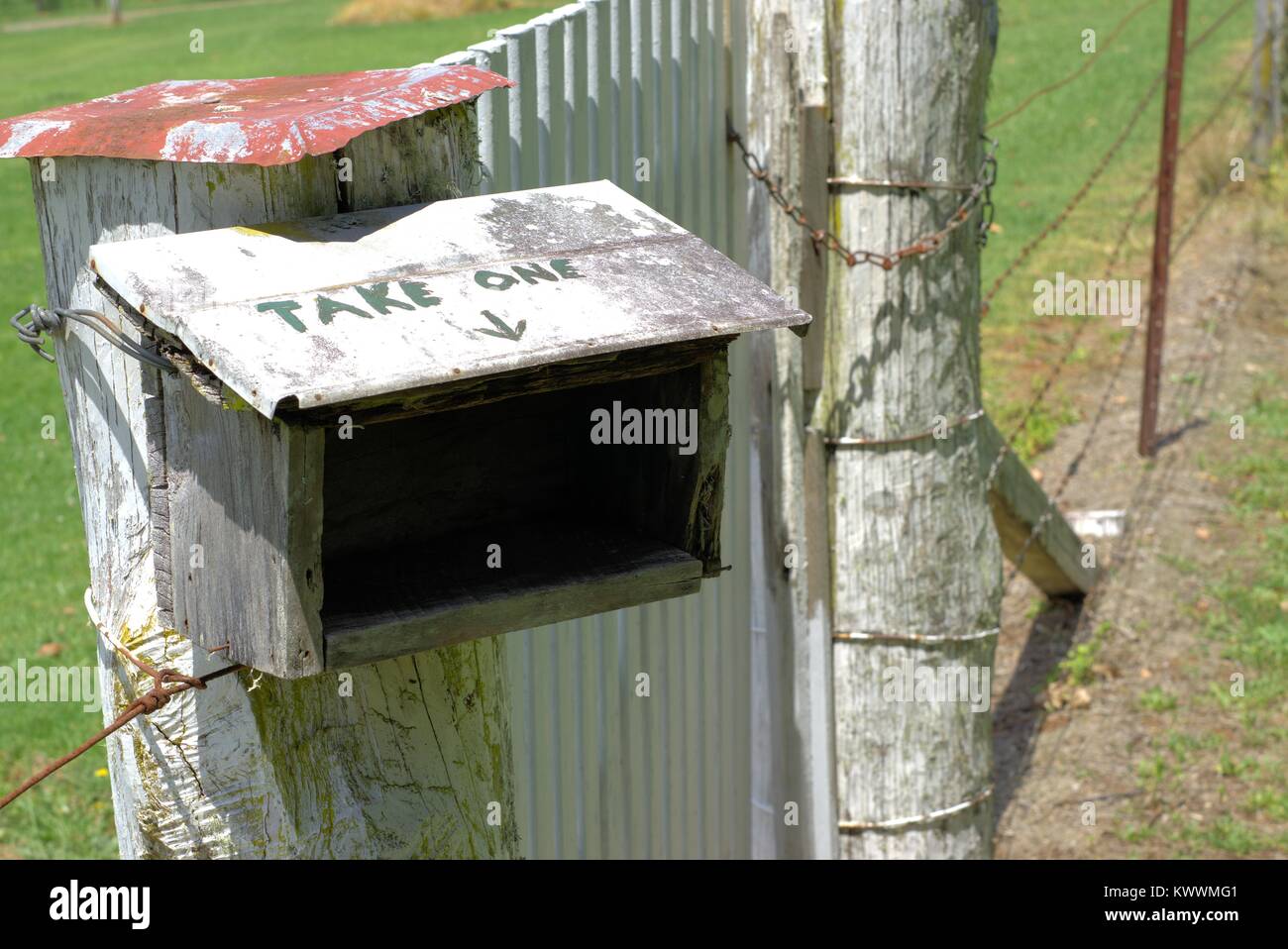Abstract image of box with Take One written on it on gate. Fence gate ...