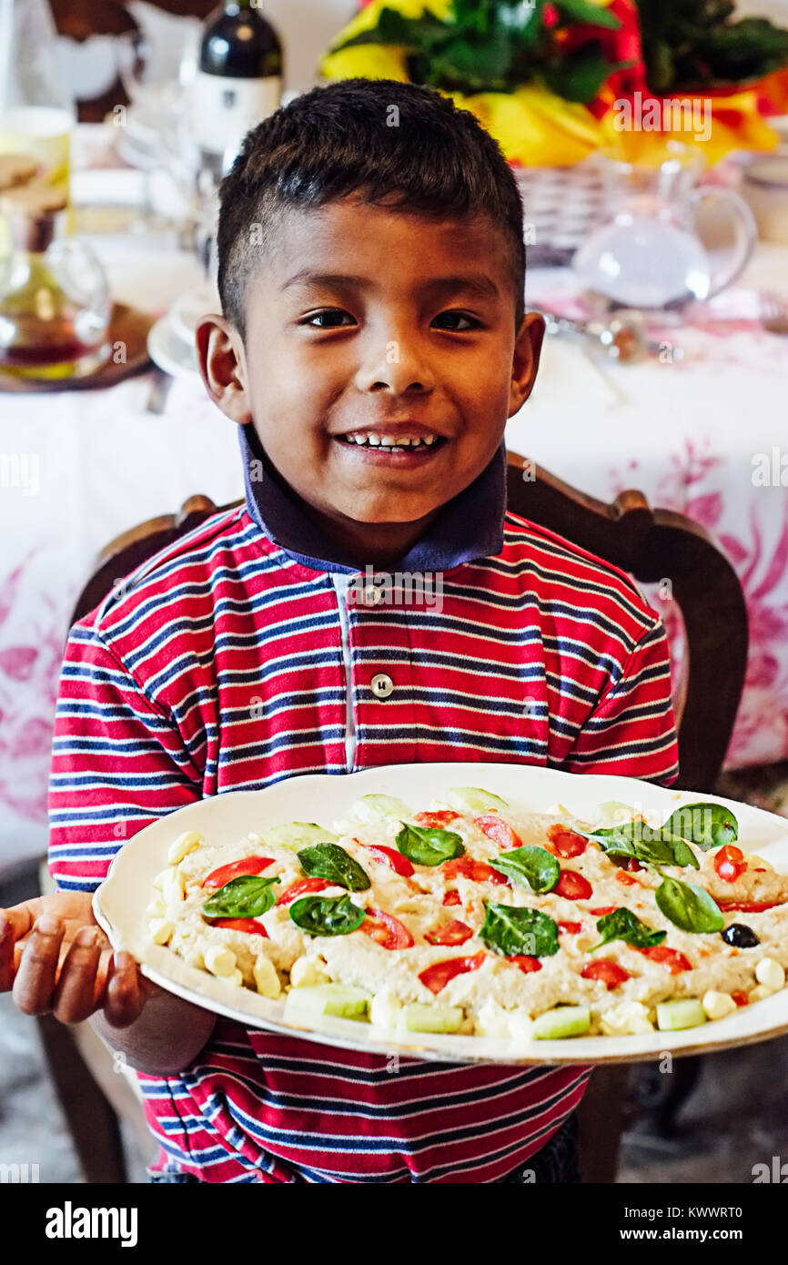 Happy latin boy smiling happy while ready to eat typical italian dish ...