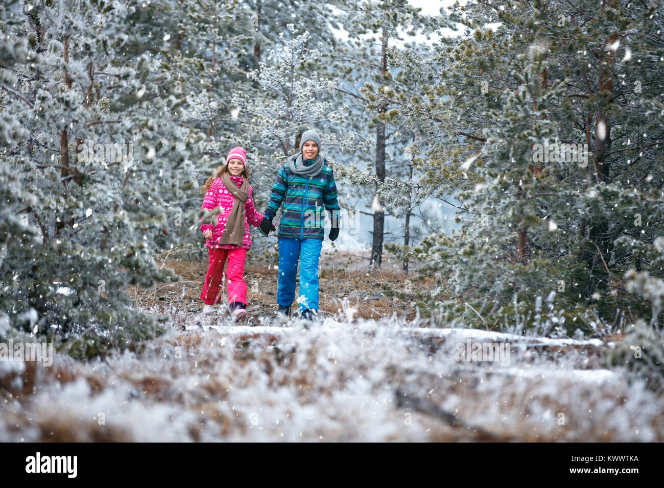 Boy and girl walking together in snowy mountain Stock Photo - Alamy